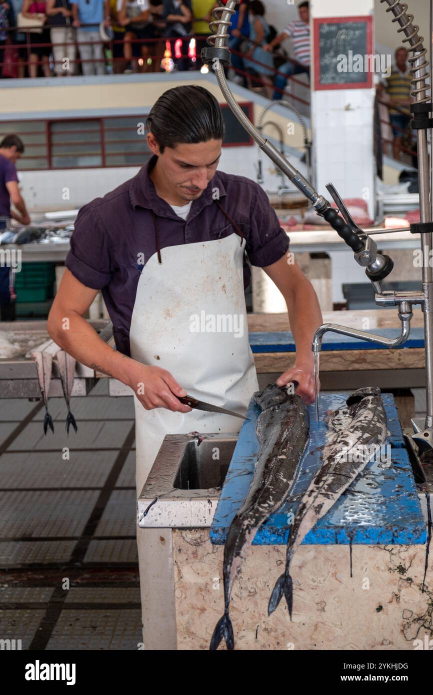 Fishmonger filleting black scabbard fish at Madeira fish market Stock ...