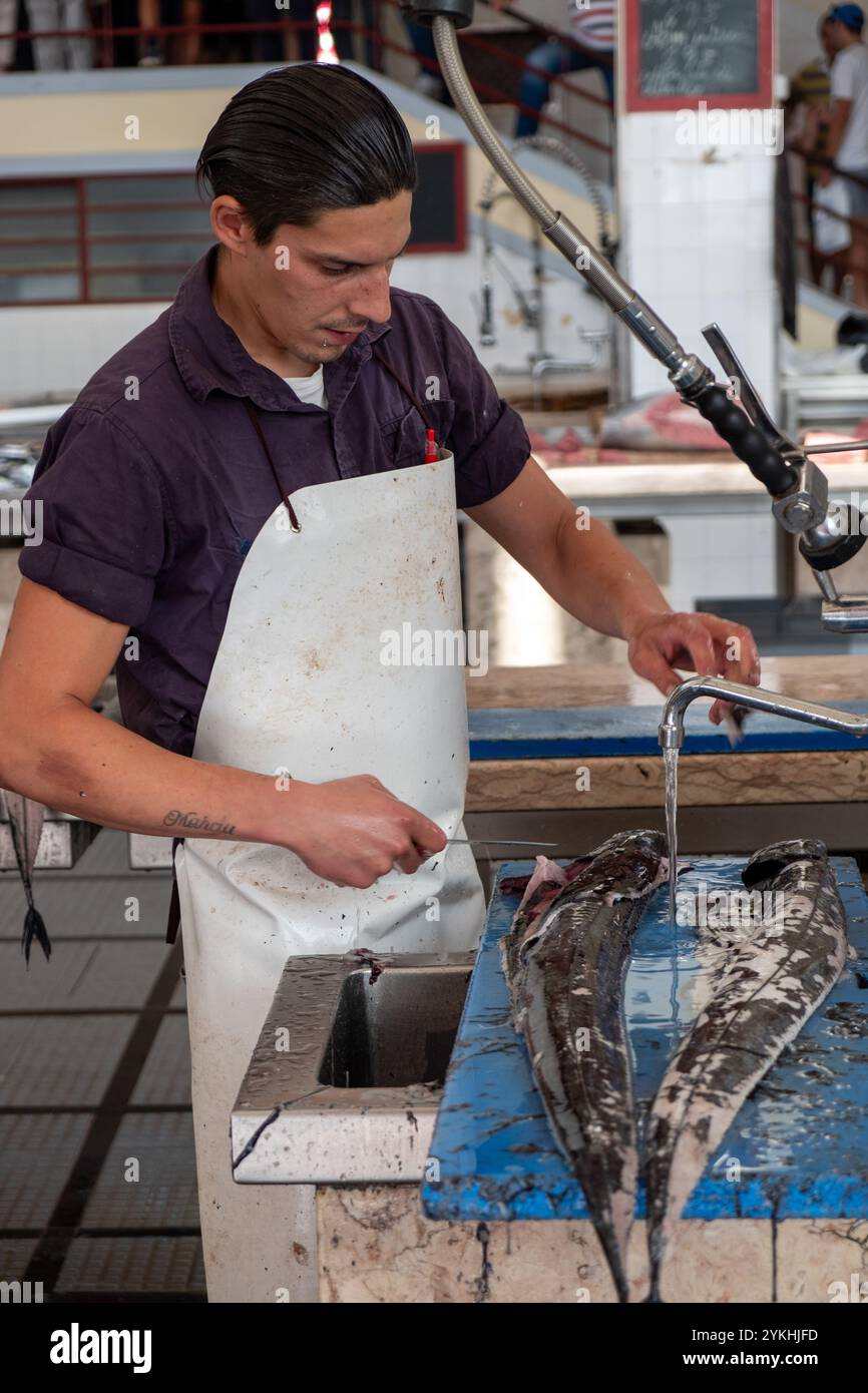 Fishmonger filleting black scabbard fish at Madeira fish market Stock ...