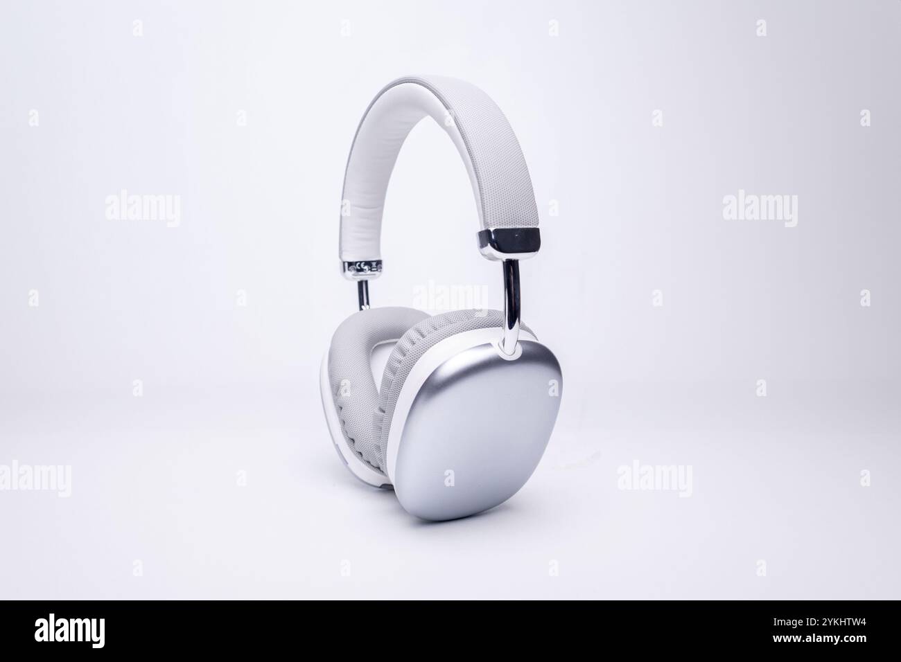 Stylish silver and white wireless headphones stand ready for listening ...