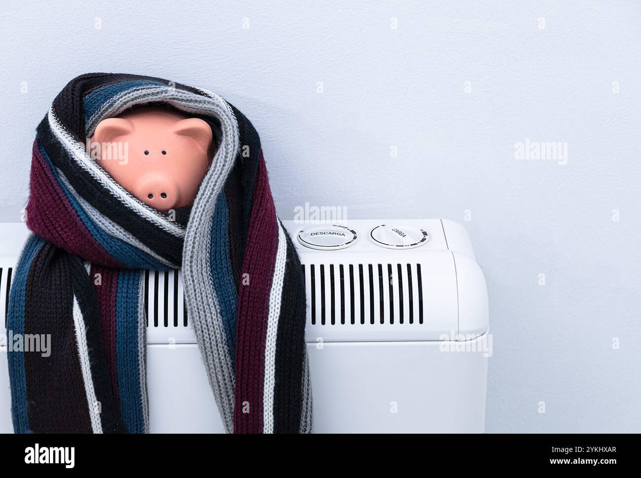 Energy saving. Electric heating on white wall with piggy bank with ...