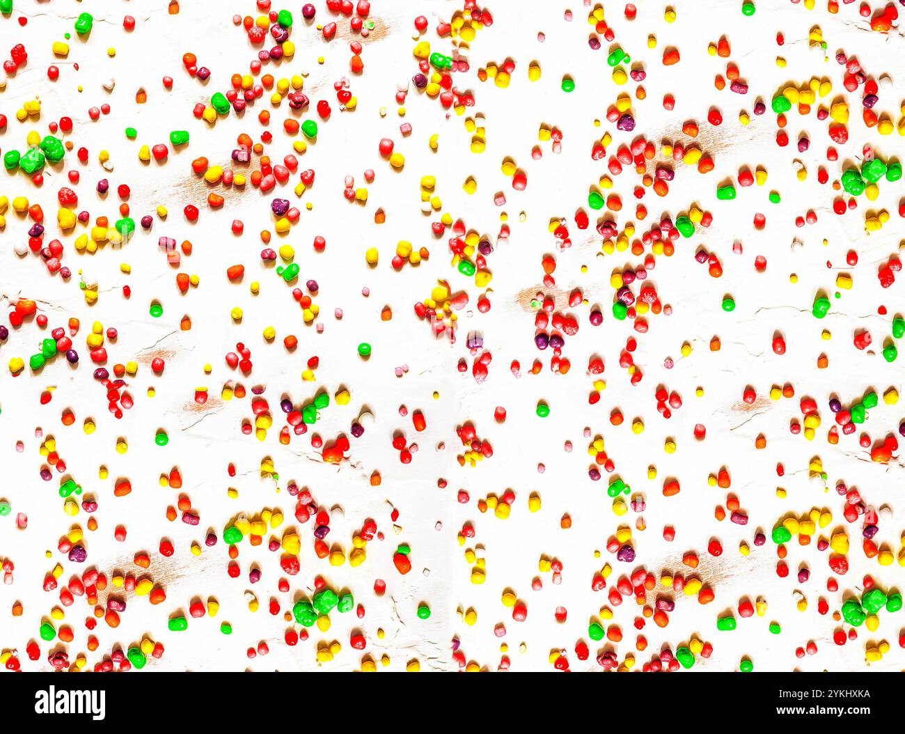 Rainbow colored candy sprinkled on a white background Stock Photo - Alamy