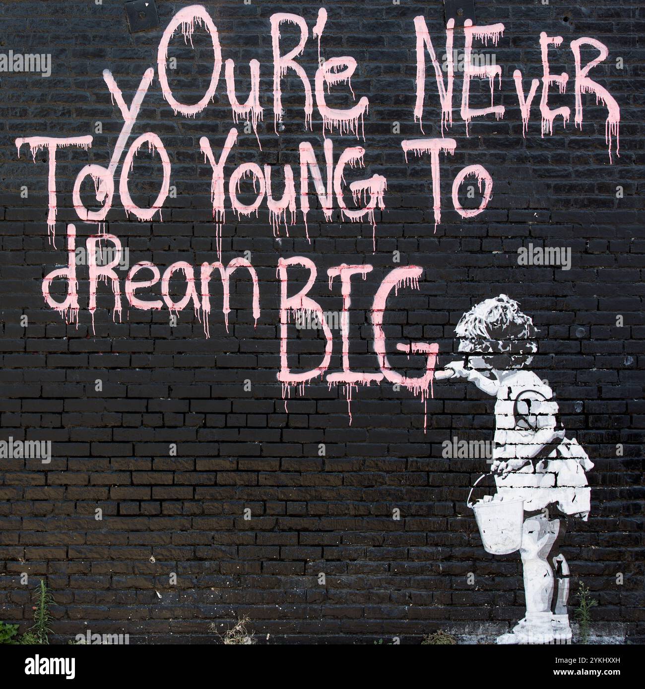 Inspirational street art with child painting "You're never too young to ...