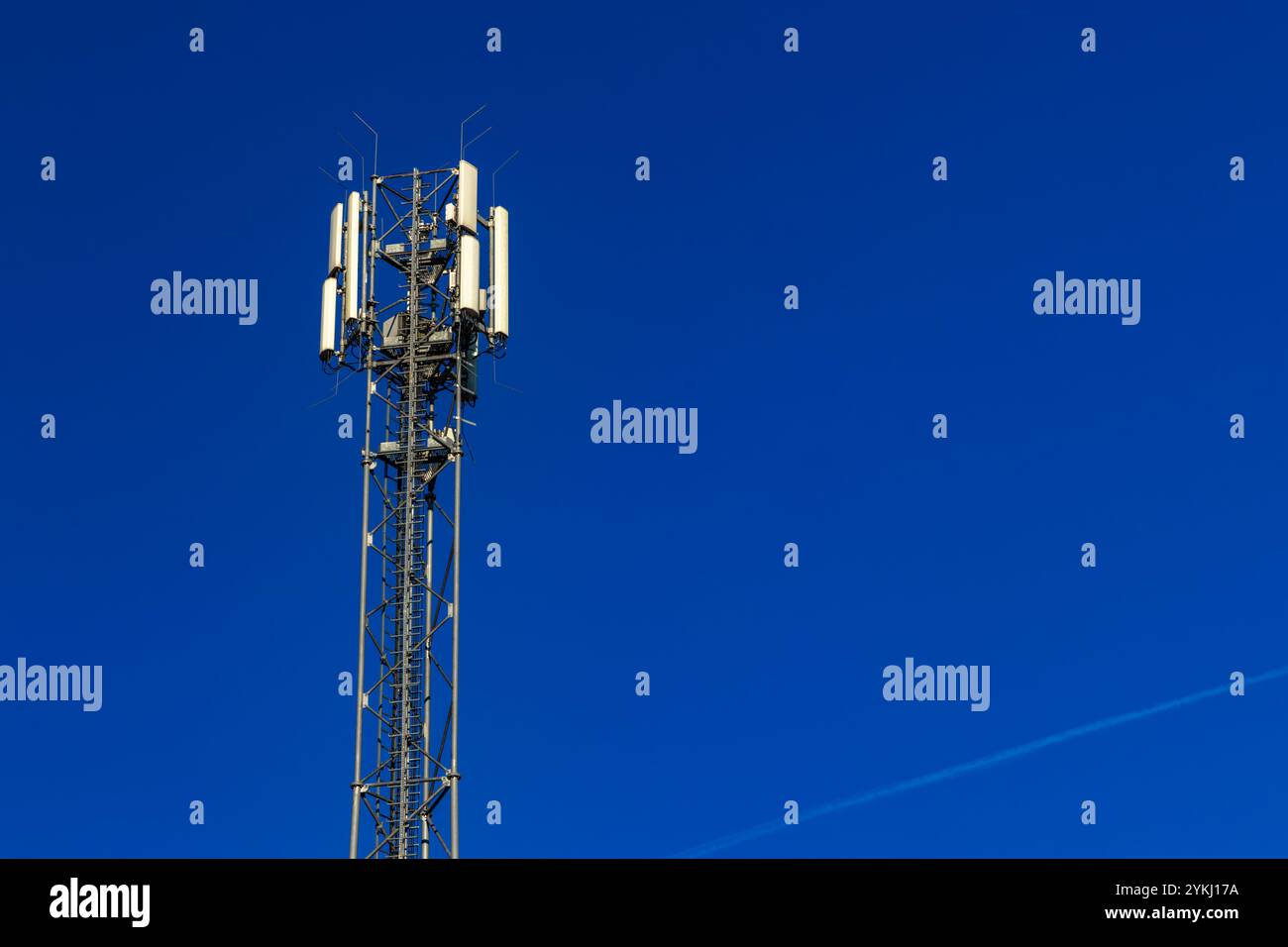 High 5g mobile antenna against blue sky background Stock Photo - Alamy