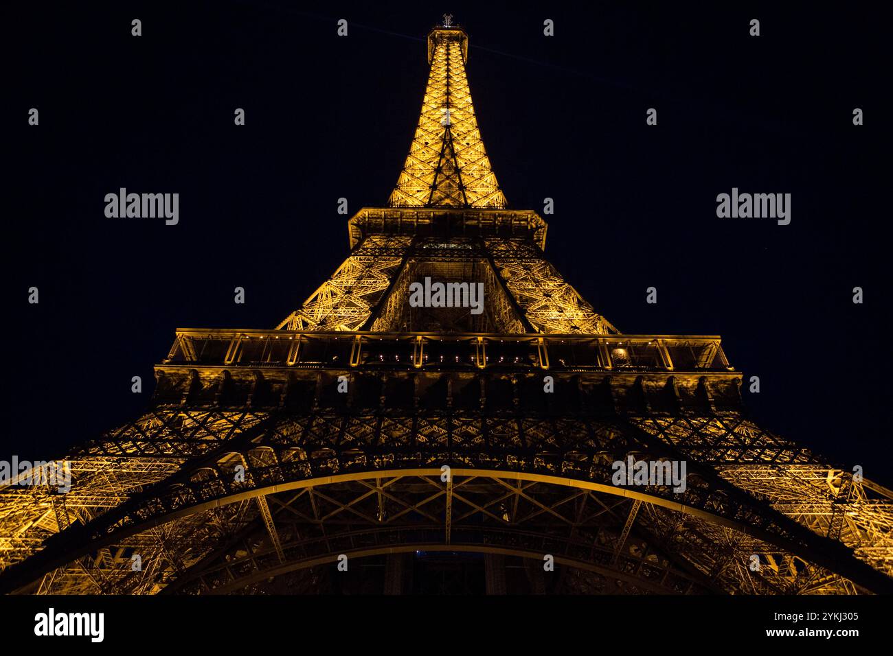 Eiffel Tower illuminated at night from a low angle Stock Photo - Alamy