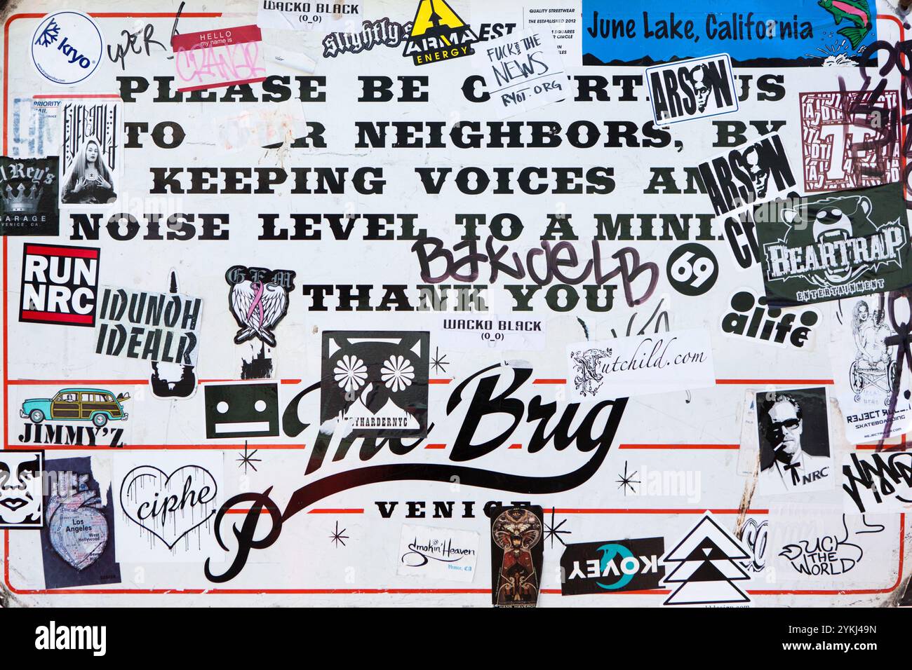 Sticker-covered signboard with urban graffiti style Stock Photo - Alamy