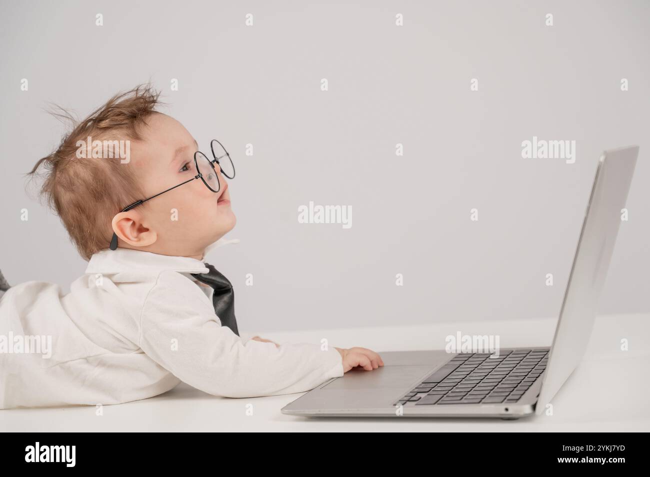 Cute baby in glasses and suit working on laptop Stock Photo - Alamy