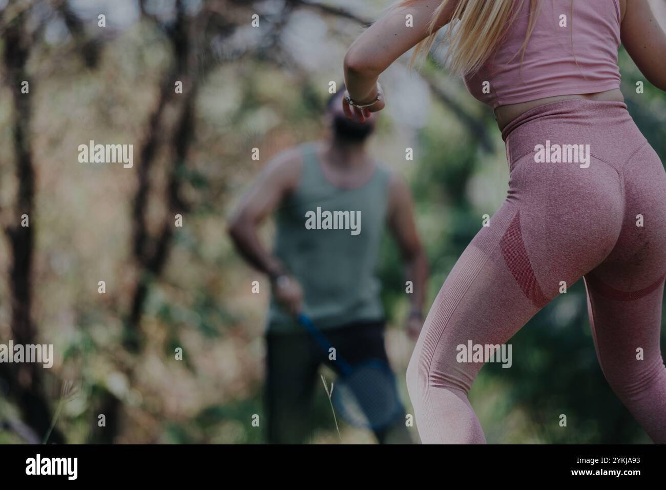 Two friends playing badminton in a sunny park setting Stock Photo - Alamy