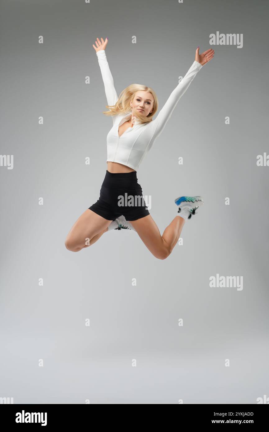 Young athlete performing a dynamic jump in a studio during a fitness ...