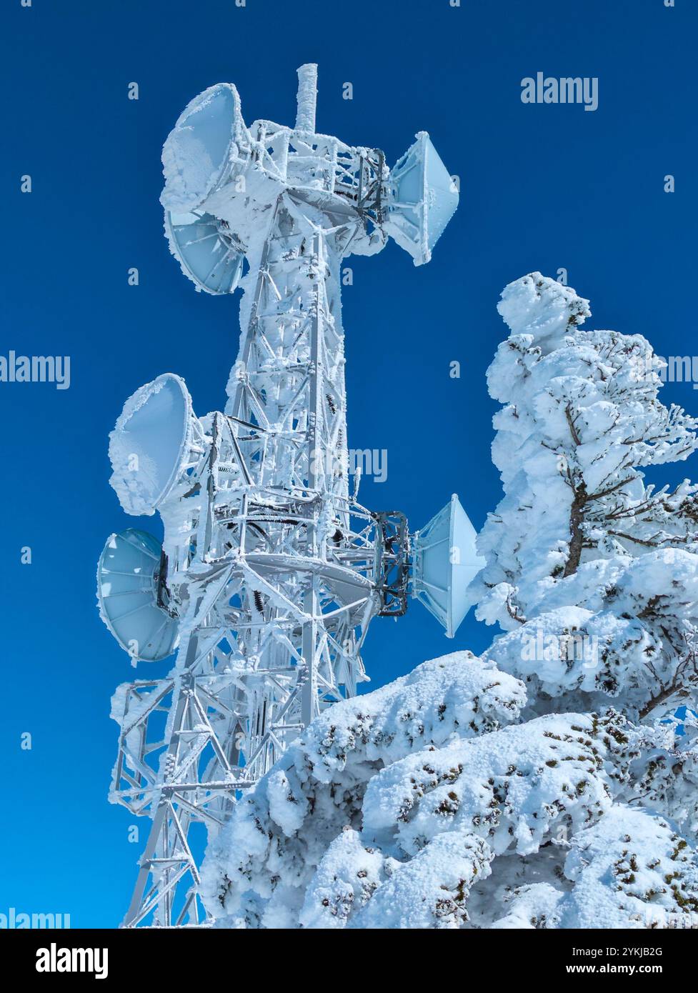 Microwave dishes and radio antenna on a mountain covered in snow and ...