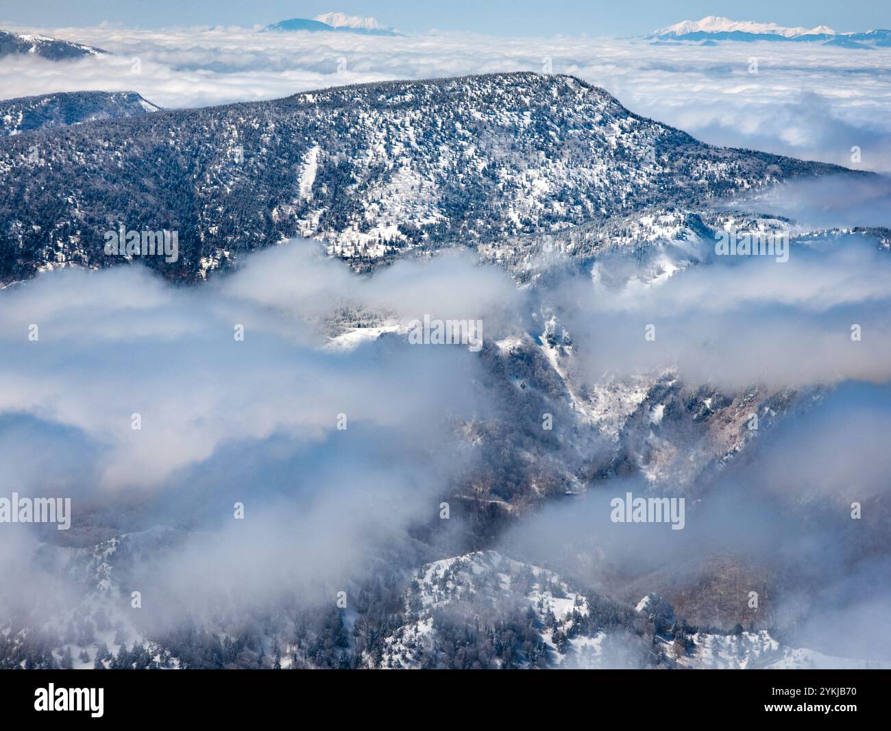 Snowy mountains and forests shrouded in a layer of cloud (Yokoteyama ...