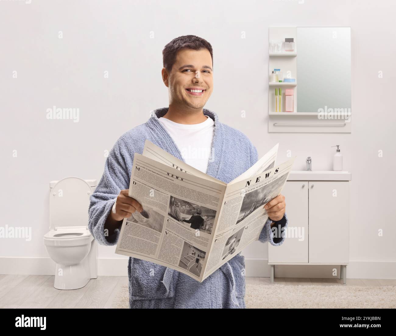 Man in pyjamas and bathrobe holding a newspaper in a bathroom Stock ...