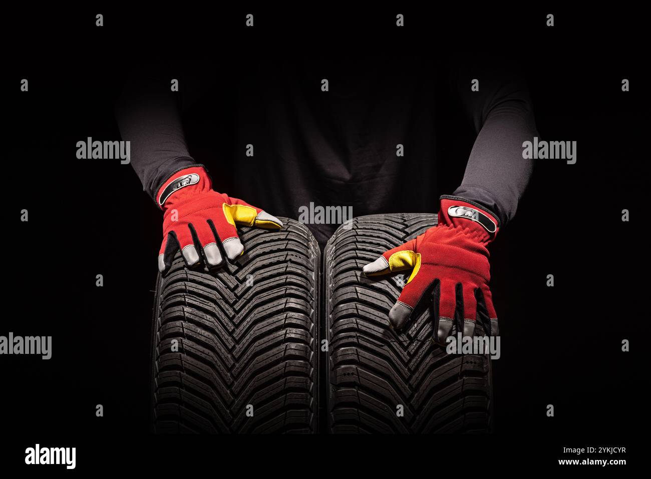 Car tire service and hands of mechanic holding new tyre on black ...