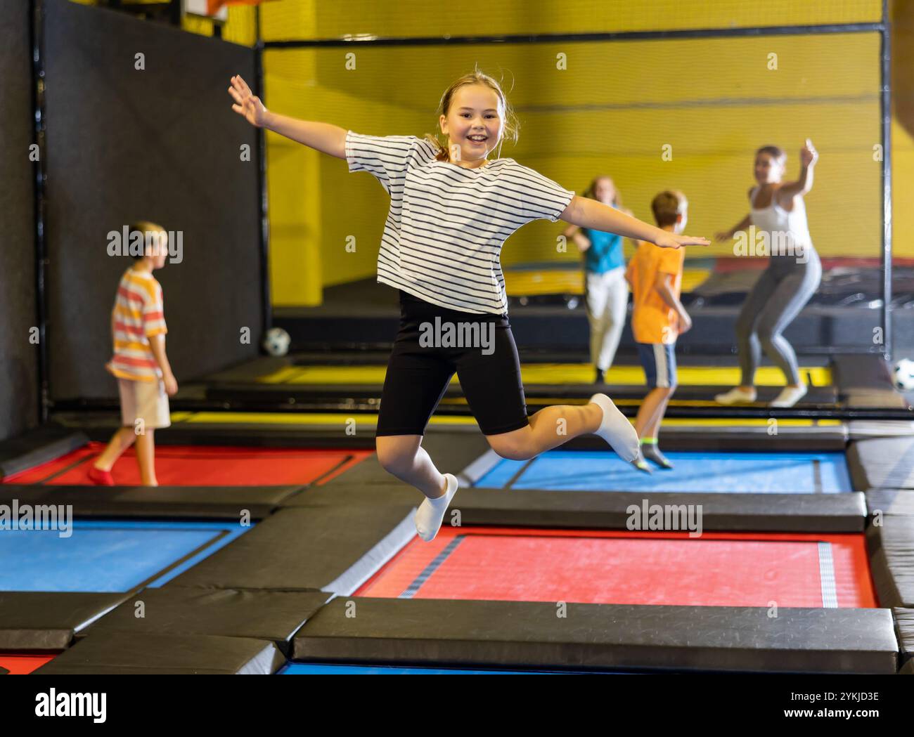 Tween girl having fun jumping in indoor trampoline arena Stock Photo ...