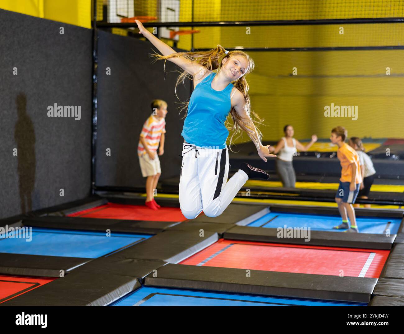 Happy teen girl in blue jersey and white pants jumping and indulging on ...