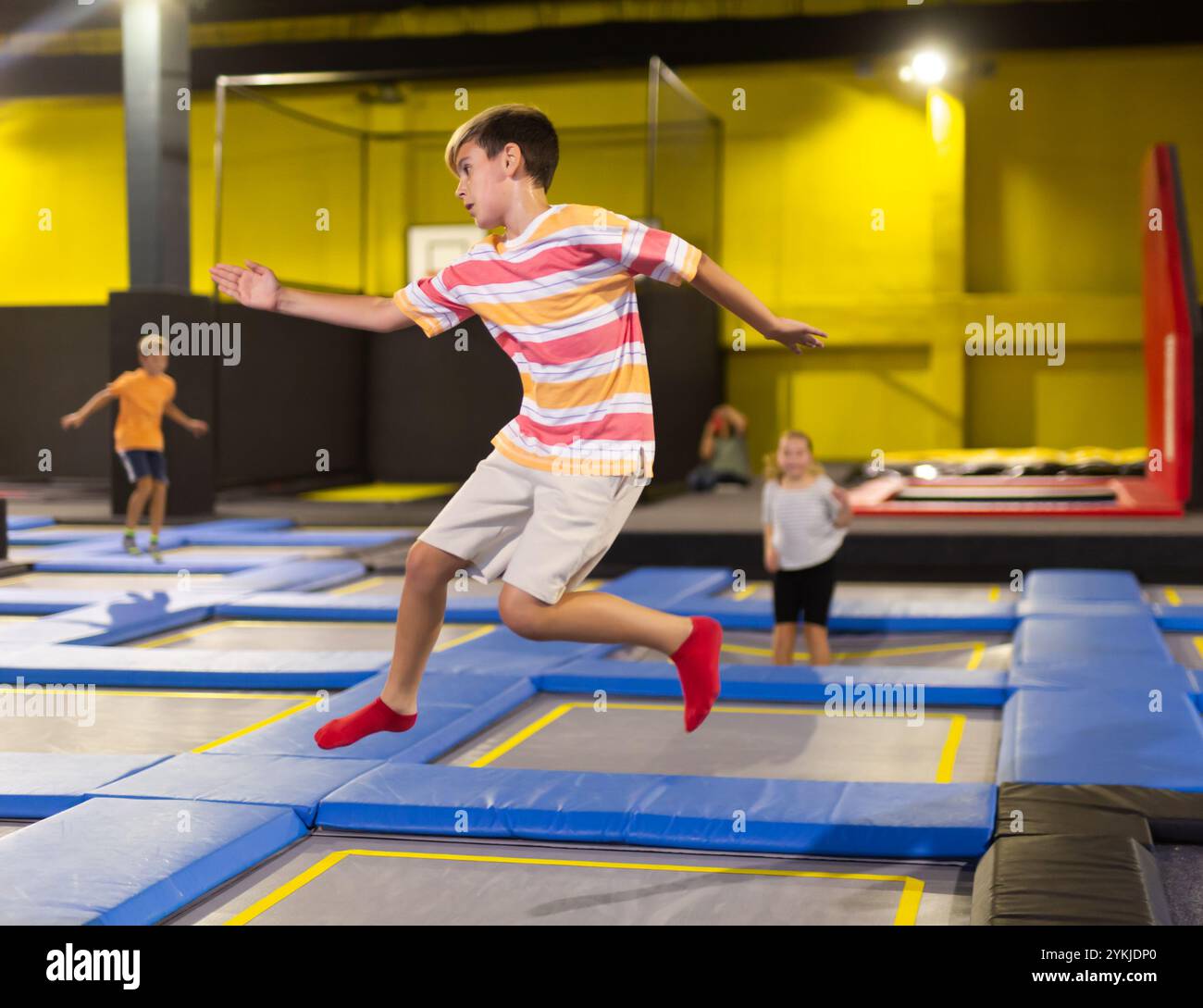 Preteen boy having while jumping in indoor trampoline arena Stock Photo ...