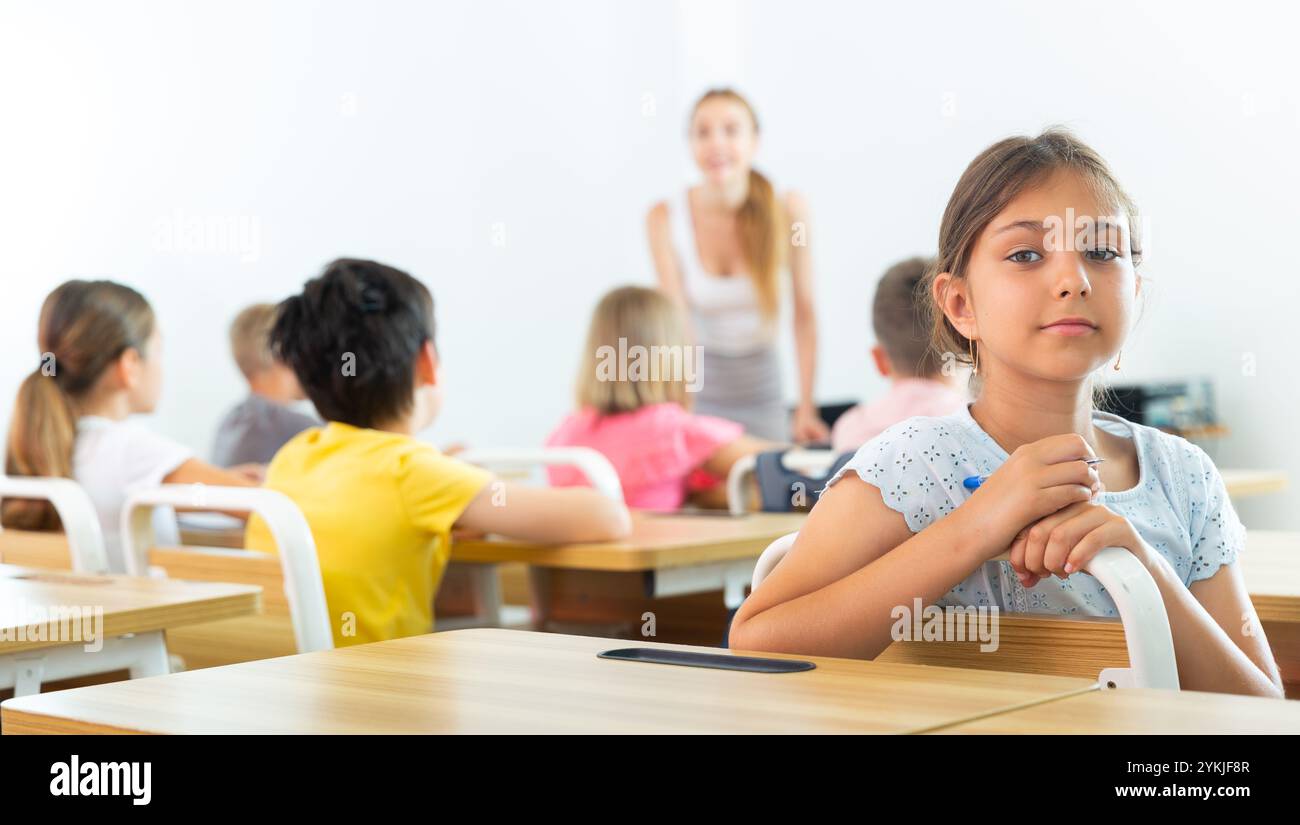 Schoolgirl sitting in classroom during lesson in elementary school ...