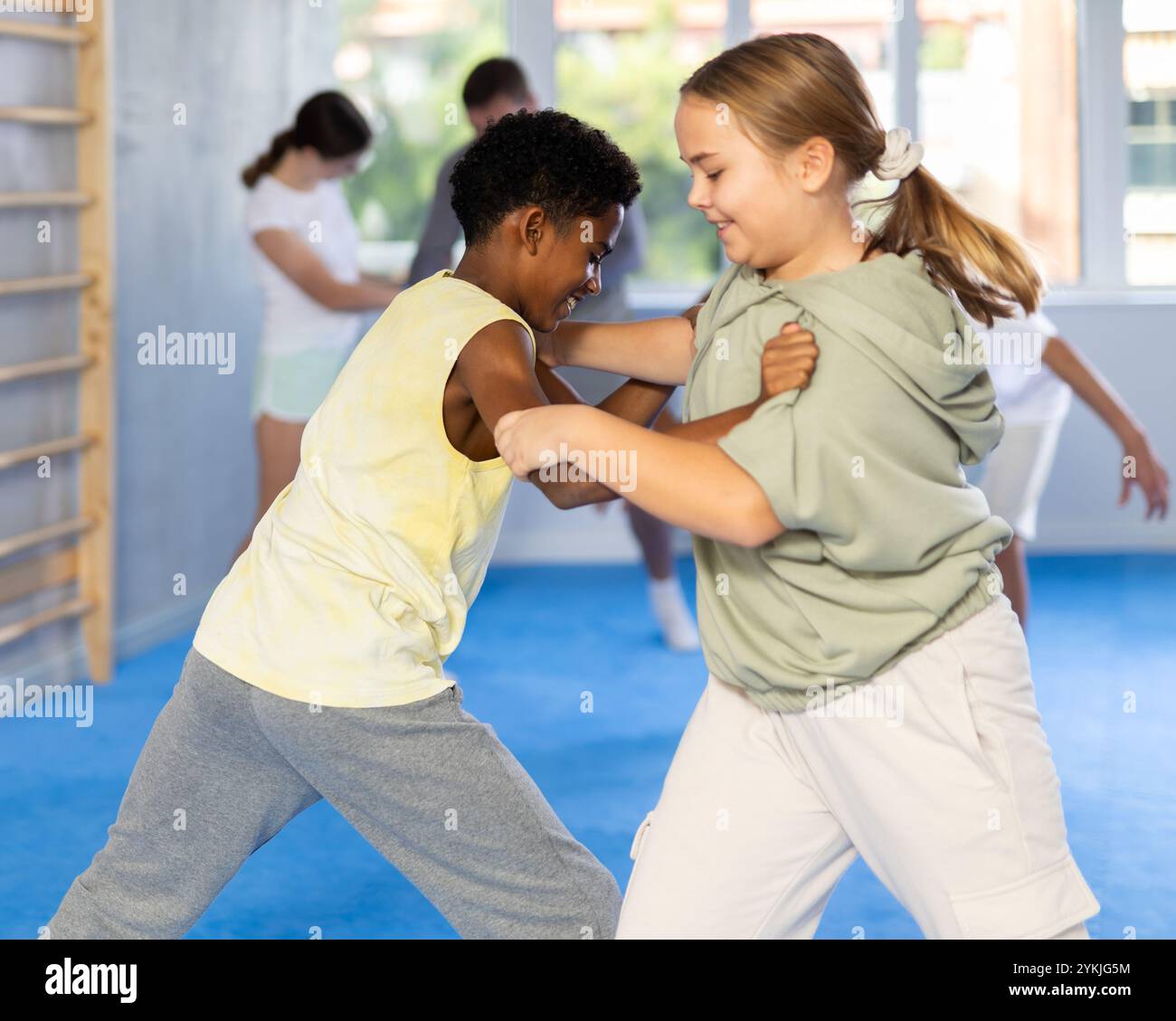 Preteen children pairs learning strength self-defense in gym Stock ...