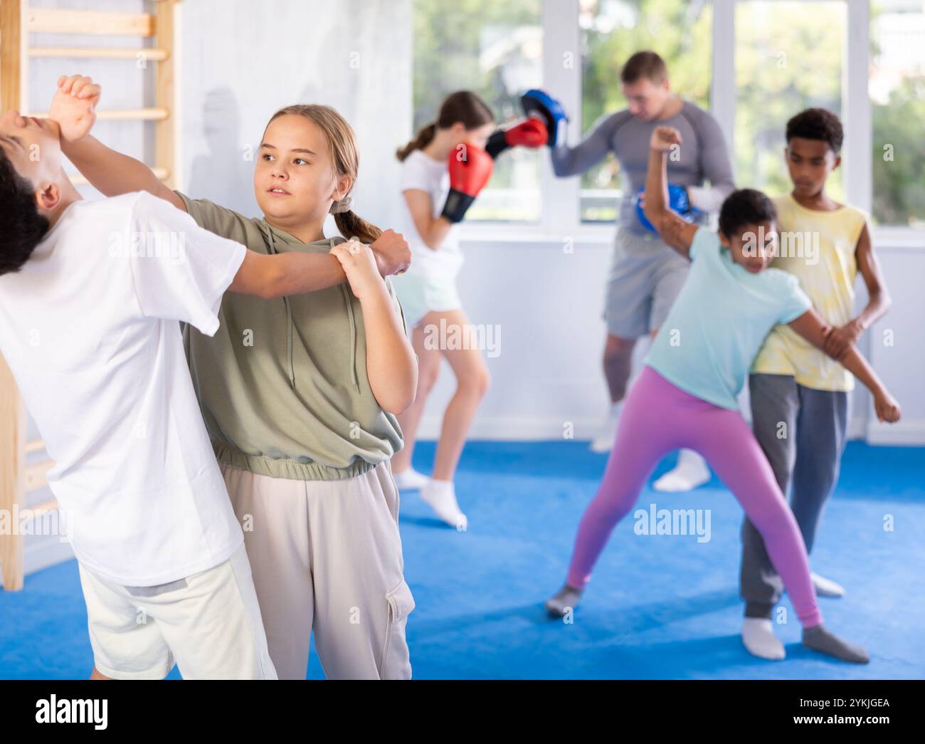 Preteen children pairs learning strength self-defense in gym Stock ...