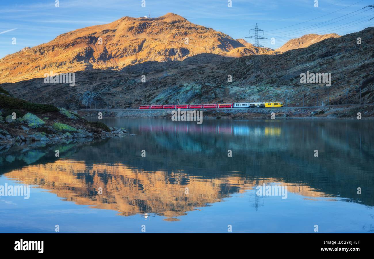 Bernina express train and alpine lake with colorful reflections Stock ...