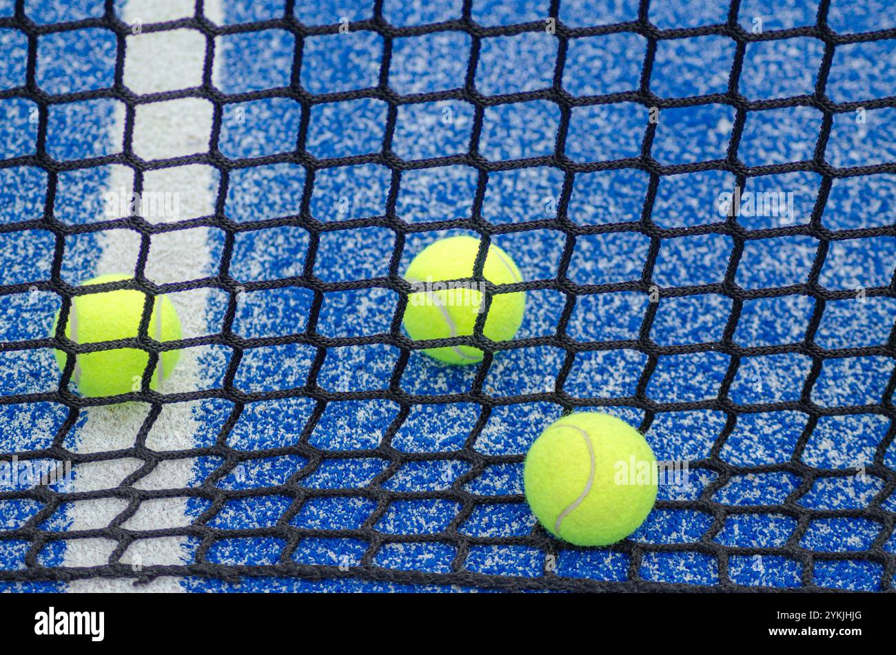 three paddle tennis balls behind the net of a paddle tennis court ...