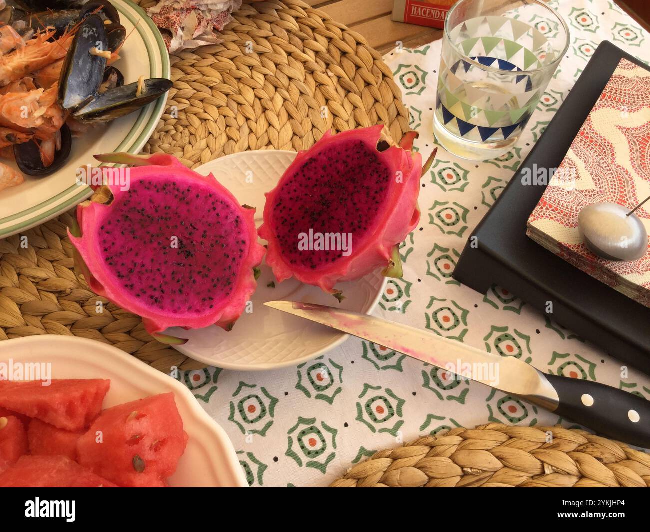 A vibrant summer table setting featuring fresh dragon fruit, sliced ...