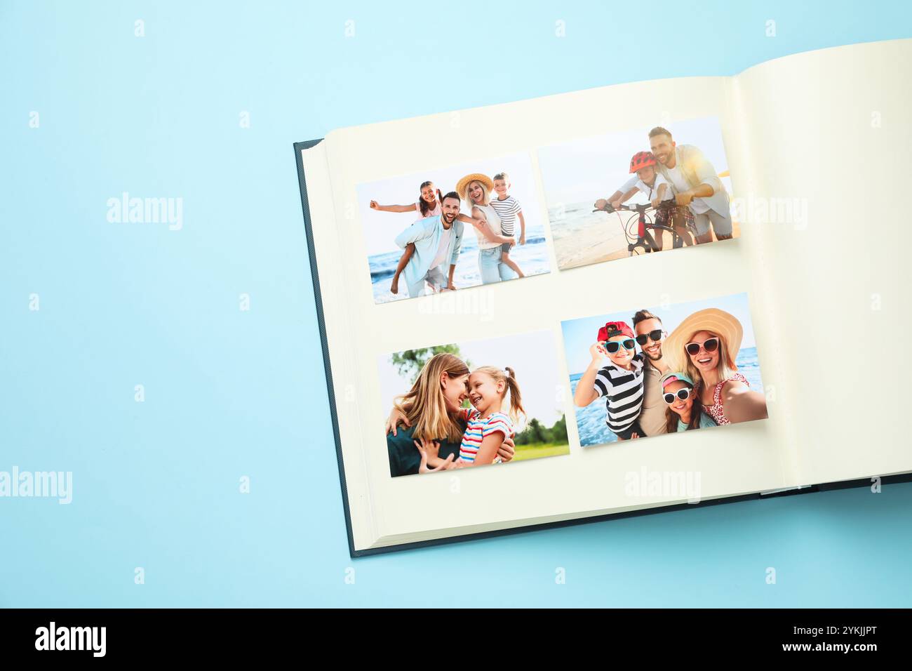 Open photo album with different photos on light blue background, top ...