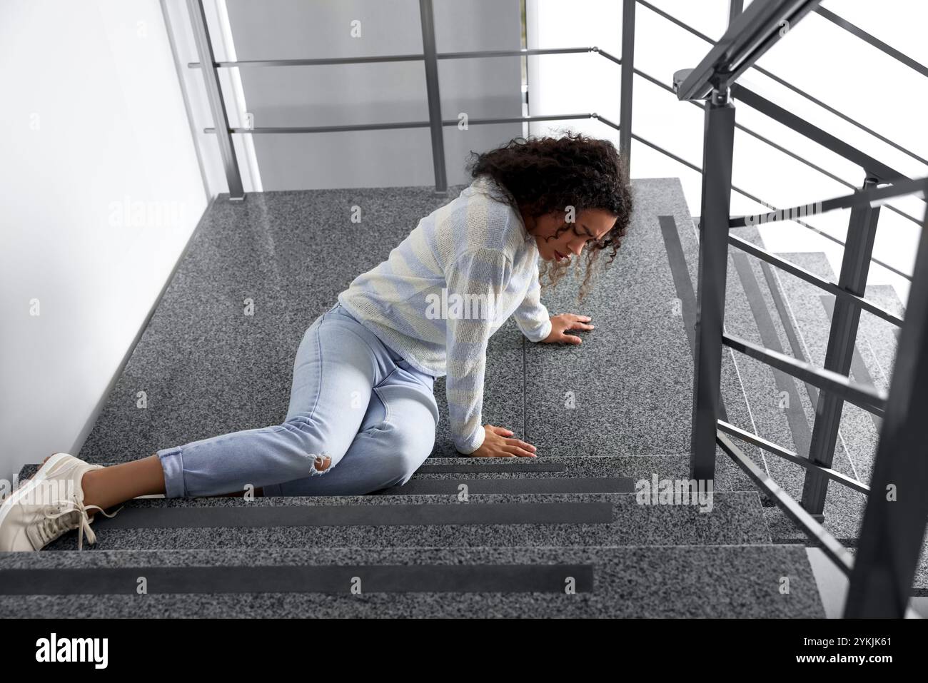 Injured woman on stairs in building after fall. Dangerous accident ...
