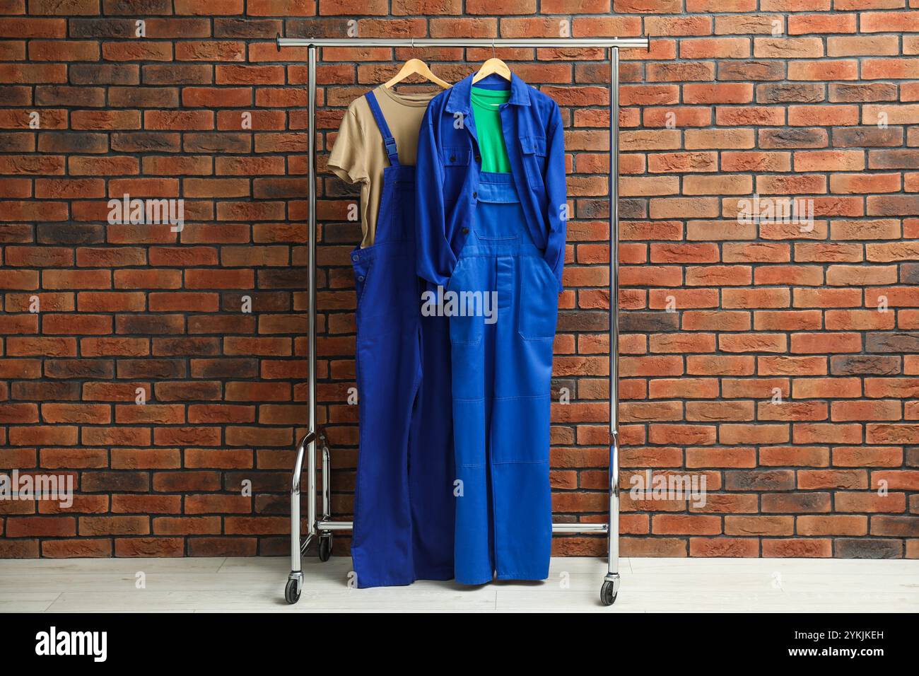 Workers' uniforms on clothing rack near brick wall Stock Photo - Alamy