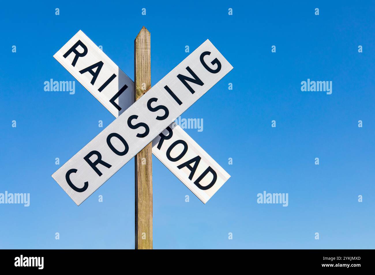 White railroad crossing warning sign isolated on blue sky. Railway ...