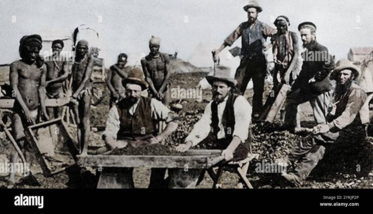Black and white miners around a diamond sorting table. Kimberley, South ...
