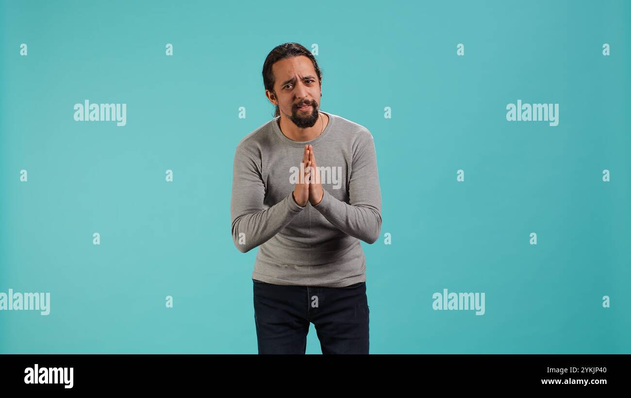 Man putting hands together in begging gesture, making wish, asking for ...