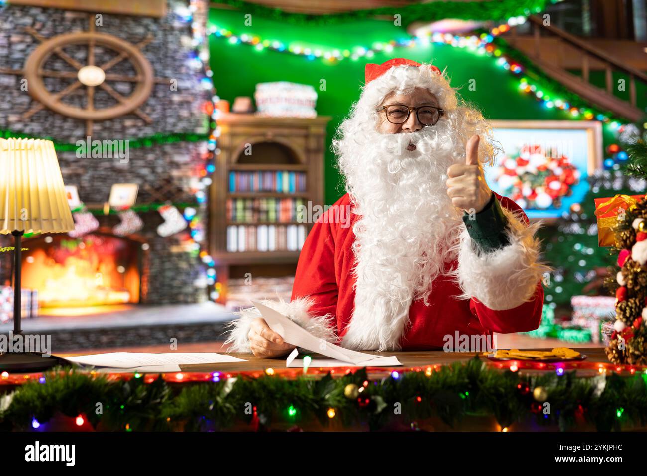 In his rustic log cabin, Santa Claus reading wish list from a hopeful ...