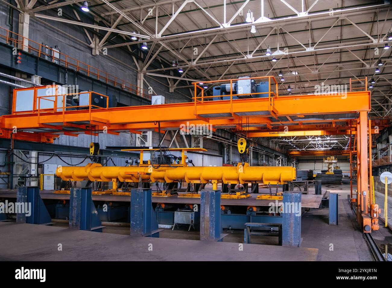 Overhead crane with magnetic grippers lifting steel sheets Stock Photo ...
