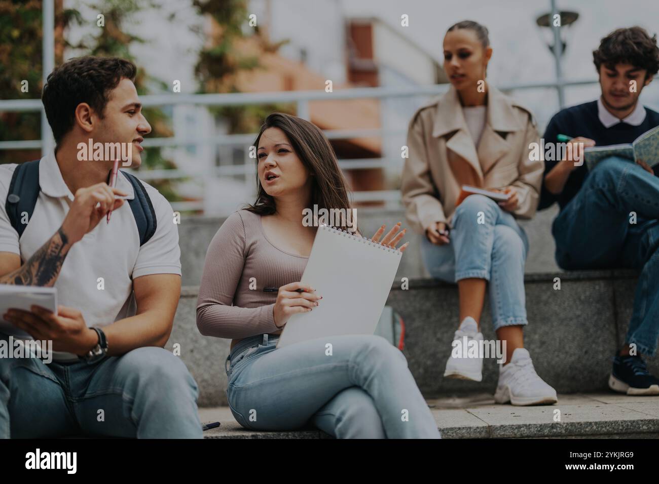 Group of students studying together in an urban setting after class ...