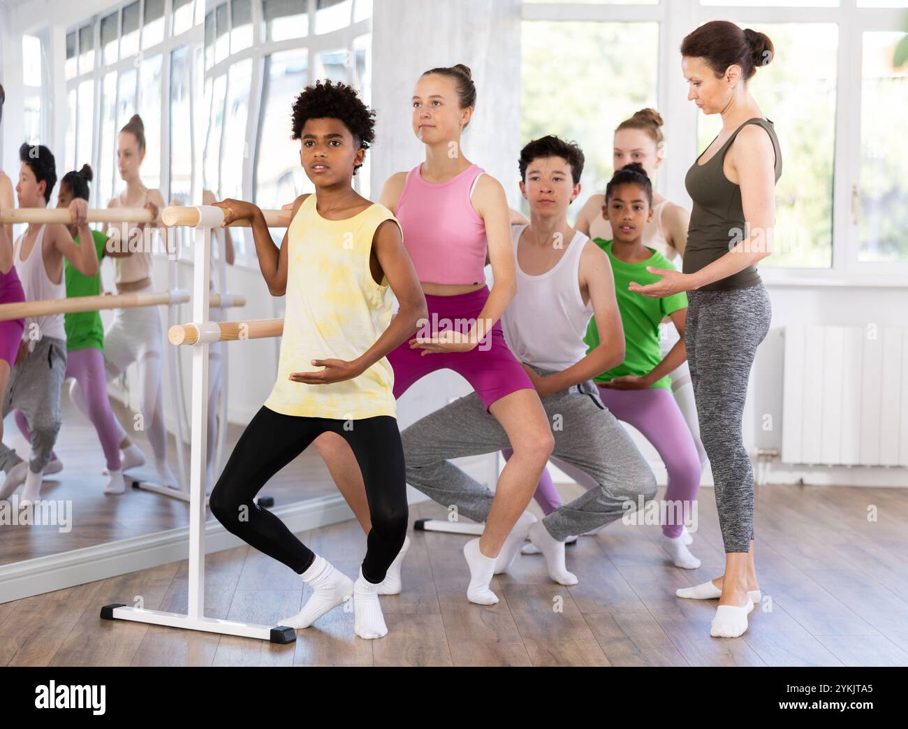 Teenage boy practicing plie position of ballet during choreography ...