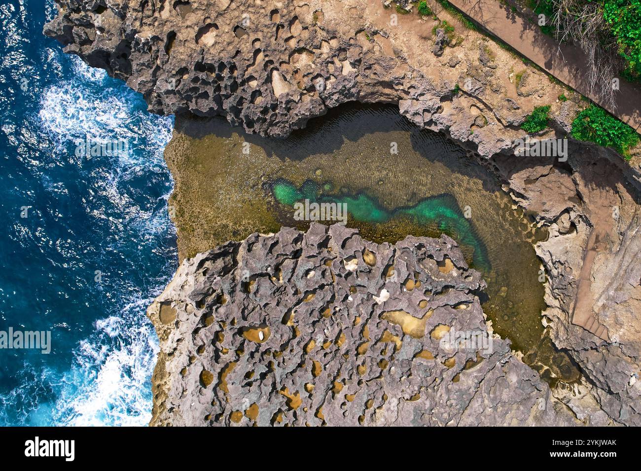 A cliff broken by the wave of the ocean. Natural azure bathing pool in ...