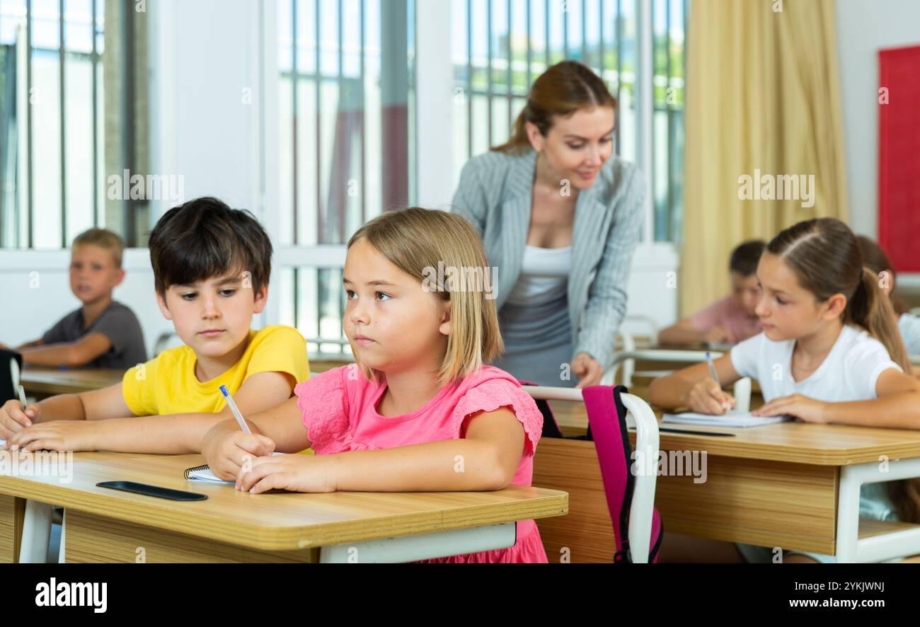 Group of school kids and teacher during lesson in classroom Stock Photo ...