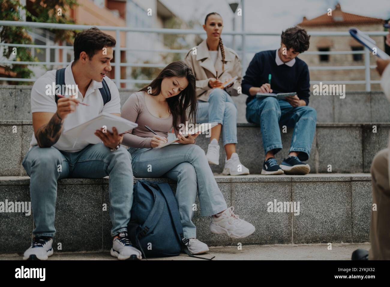 Students collaborating outdoors with guidance from their professor ...