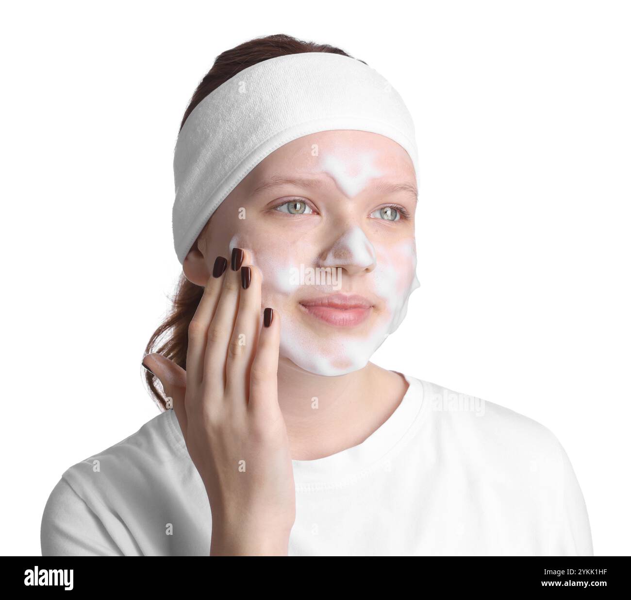 Teenage girl washing her face with cleanser on white background ...