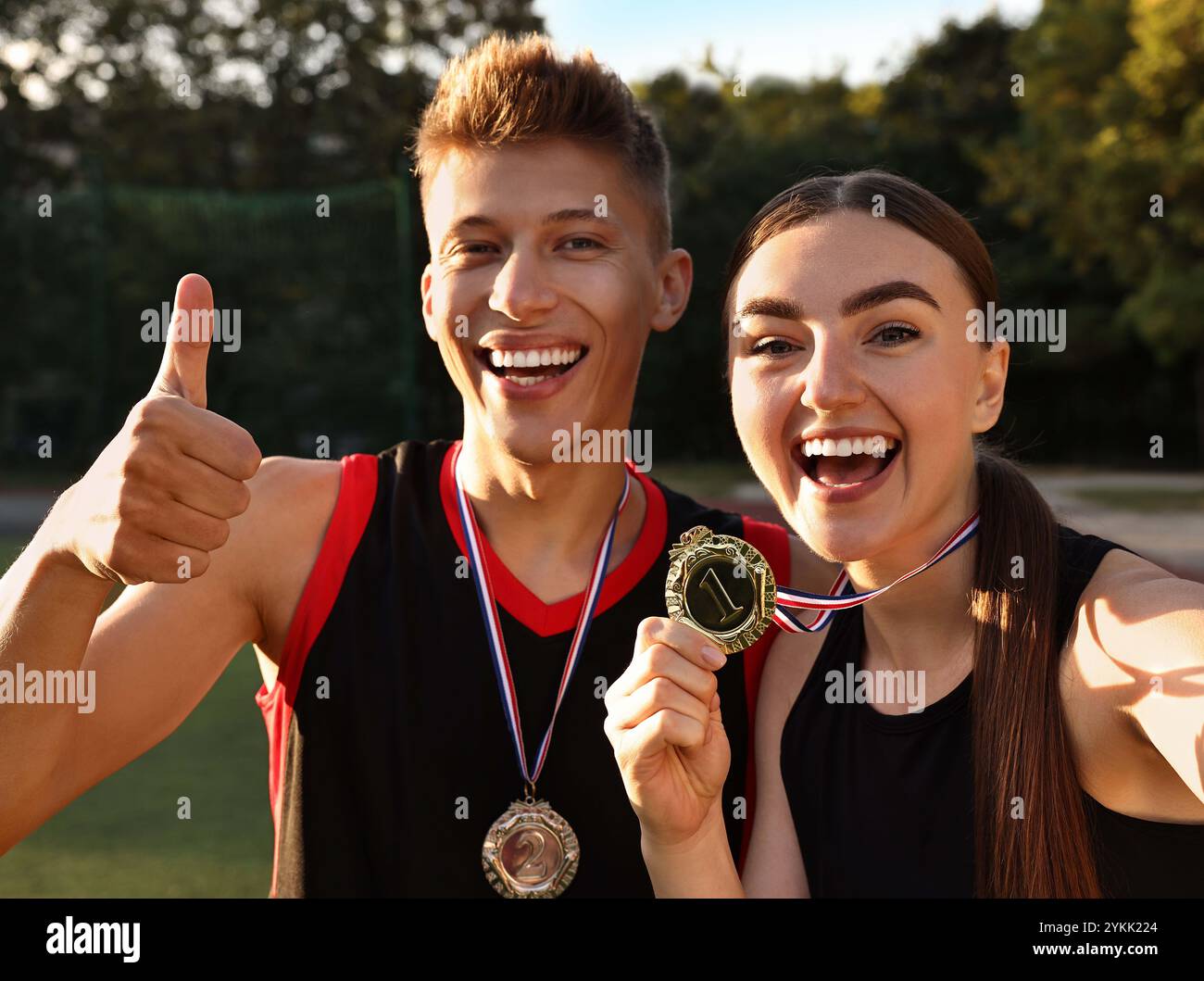 Happy winners with medals taking selfie at stadium Stock Photo - Alamy