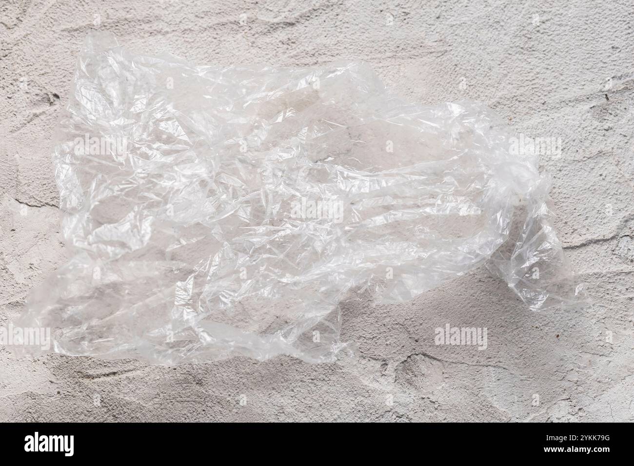 In the image you can see a crumpled and curled plastic bag on a dark ...