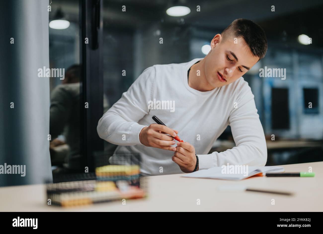 High school student concentrating on classwork at a classroom desk ...