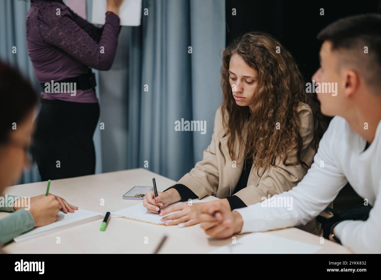 Students collaborating in a classroom setting during a group activity Stock Photo - Alamy