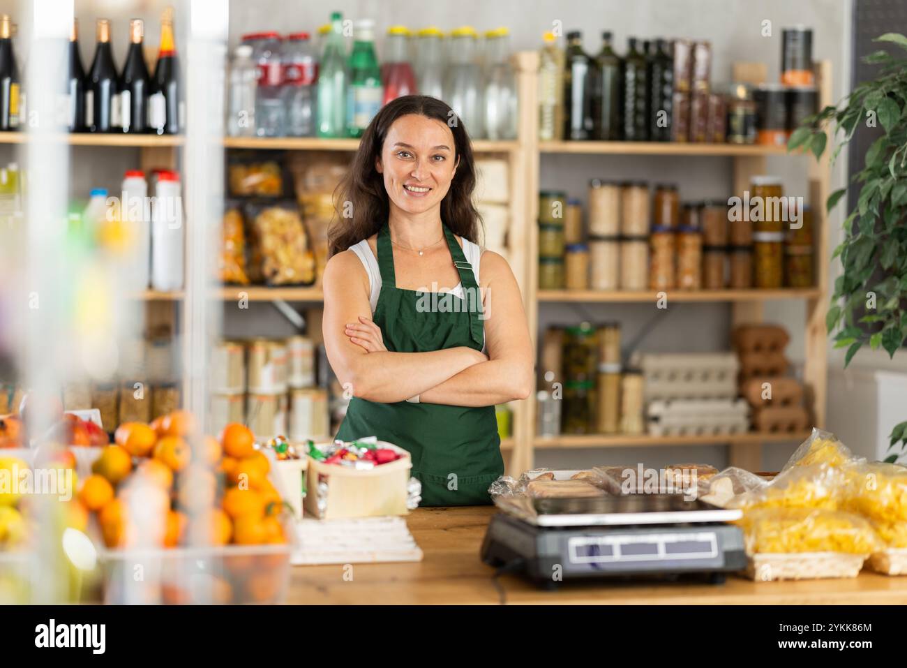 Woman works as salesperson, waiting for customers at store counter ...