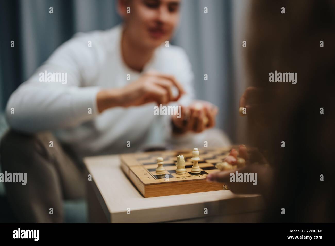 Teenagers engaging in a friendly game of chess indoors Stock Photo - Alamy
