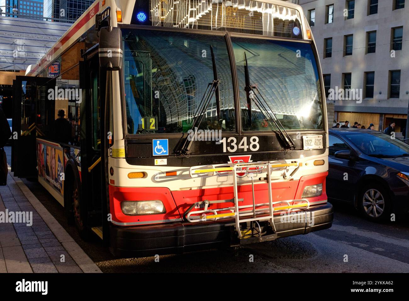The front view of a Toronto Transit Bus with reflections of the tall ...
