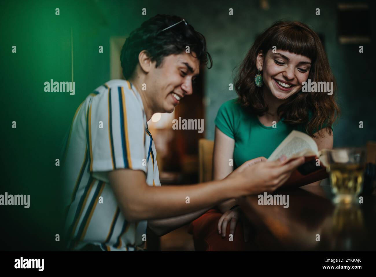Young friends enjoying a casual reading session at a cafe Stock Photo ...