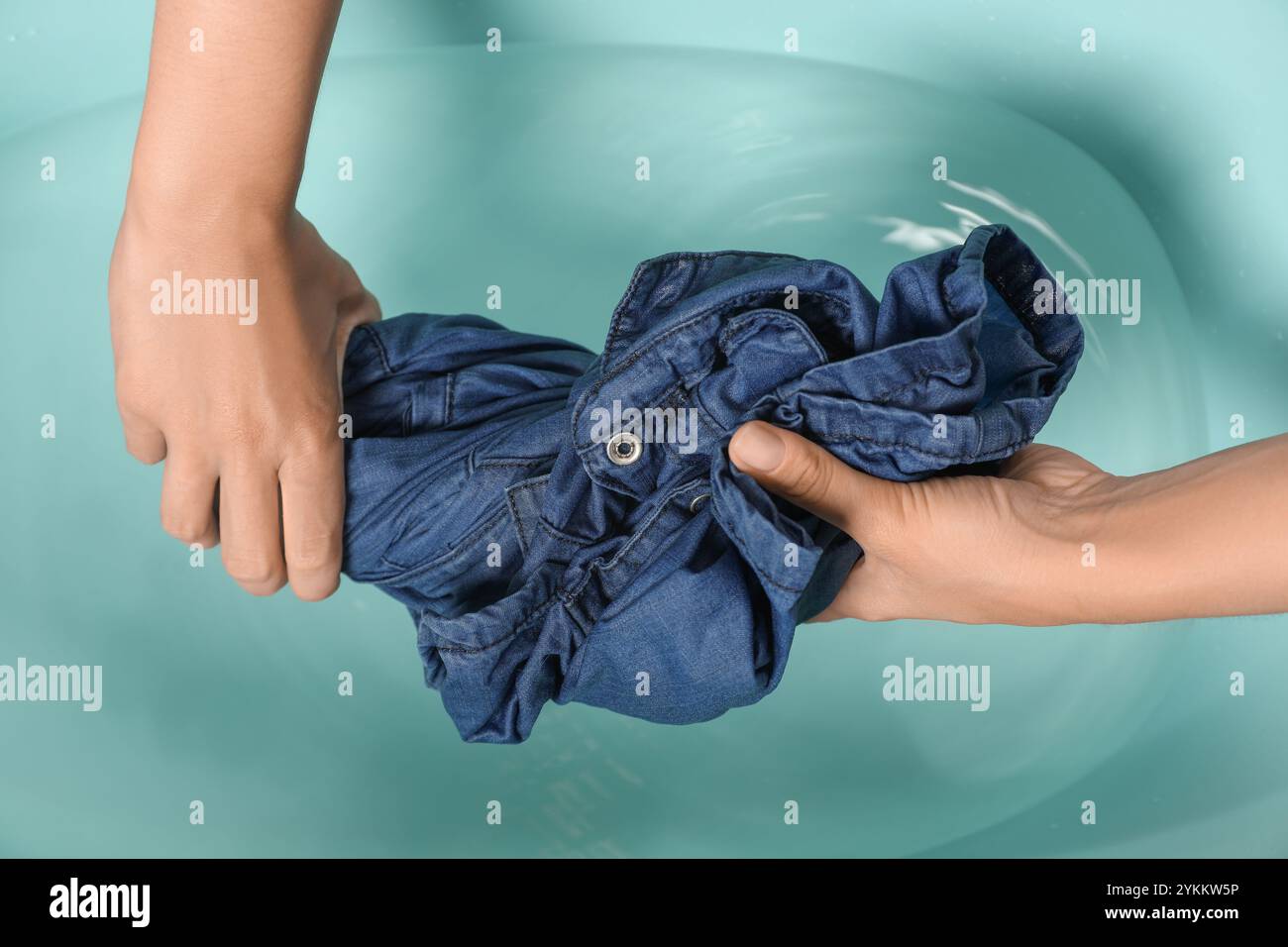 Woman washing denim clothes in basin, top view Stock Photo - Alamy