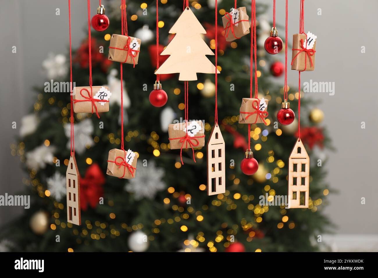 Handmade advent calendar with decor hanging near Christmas tree indoors ...