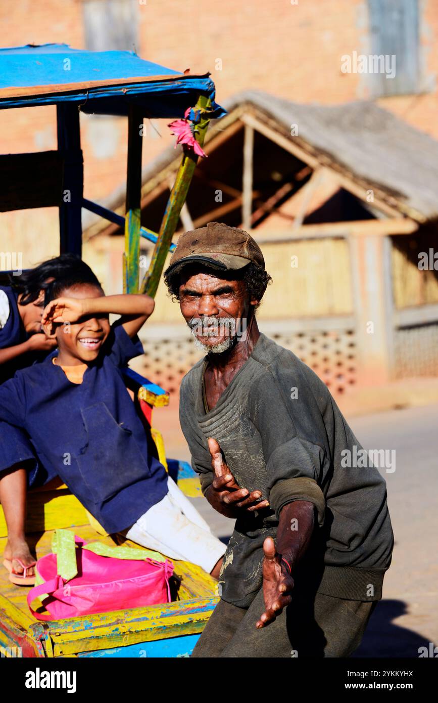 A joyful pousse-pousse driver in a small town in the central highlands ...